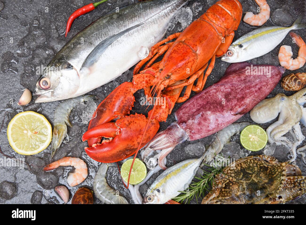 Fresh raw seafood on ice with herbs and spices at the fish market food ...