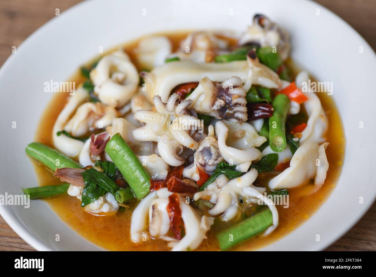 Fried squid with basil on white plate, Stir fried spicy basil leave ...