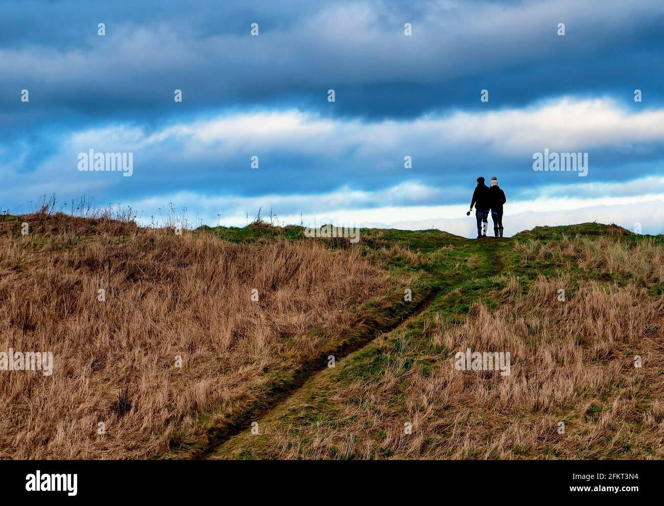 Couple pause after hiking to the top of a hill Stock Photo - Alamy