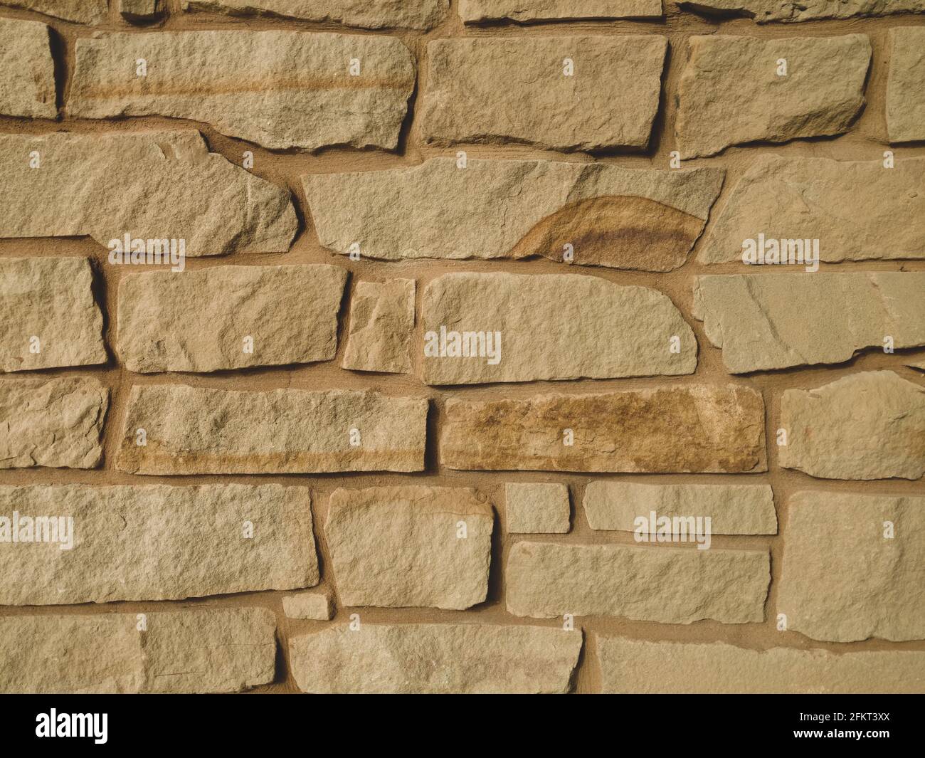 closeup view of sand stone rock wall with colored grout matching with ...