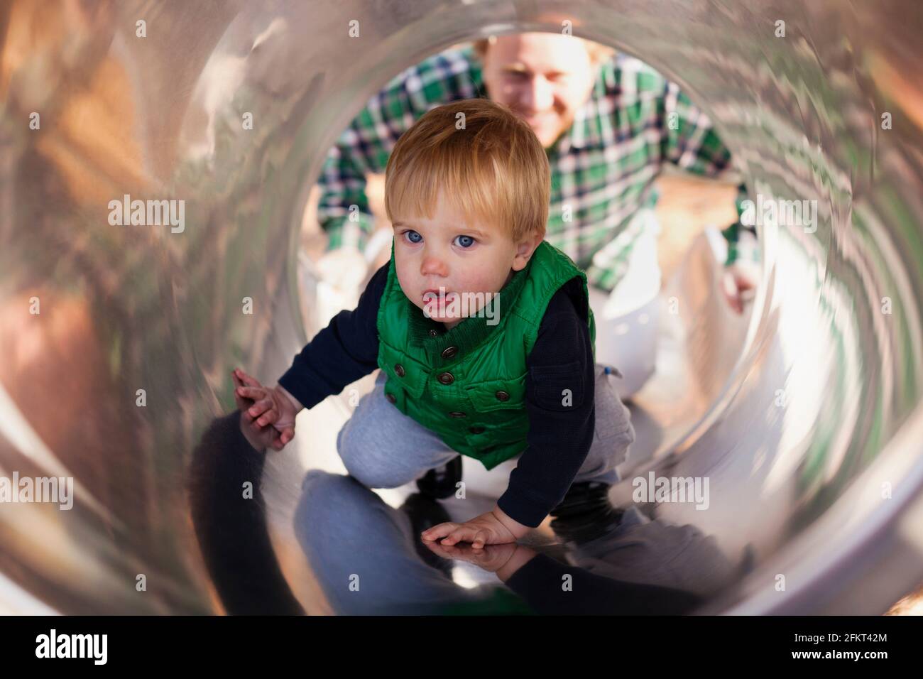Boy climbing up slide in playground Stock Photo - Alamy