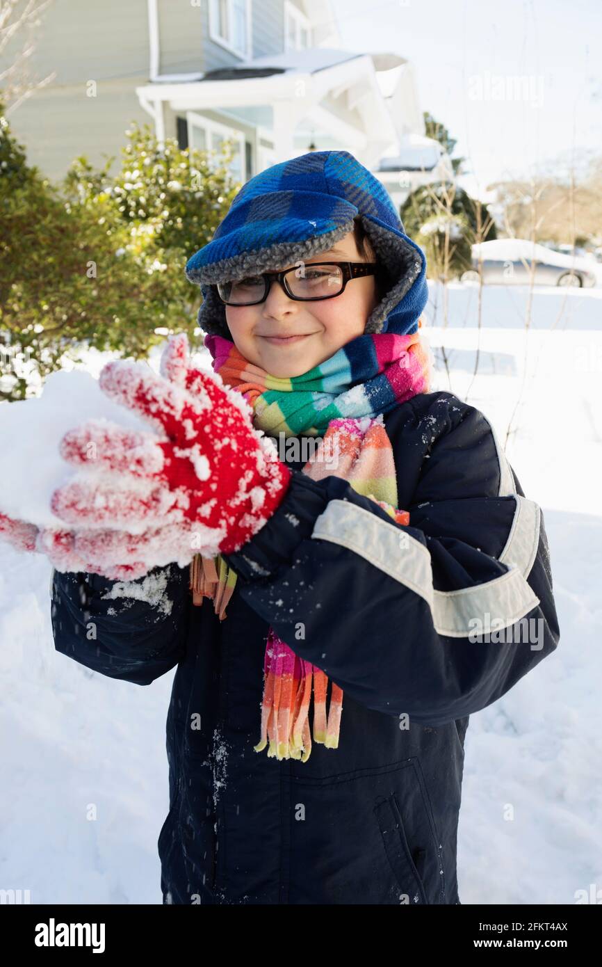 Boy making snowball, smiling Stock Photo - Alamy