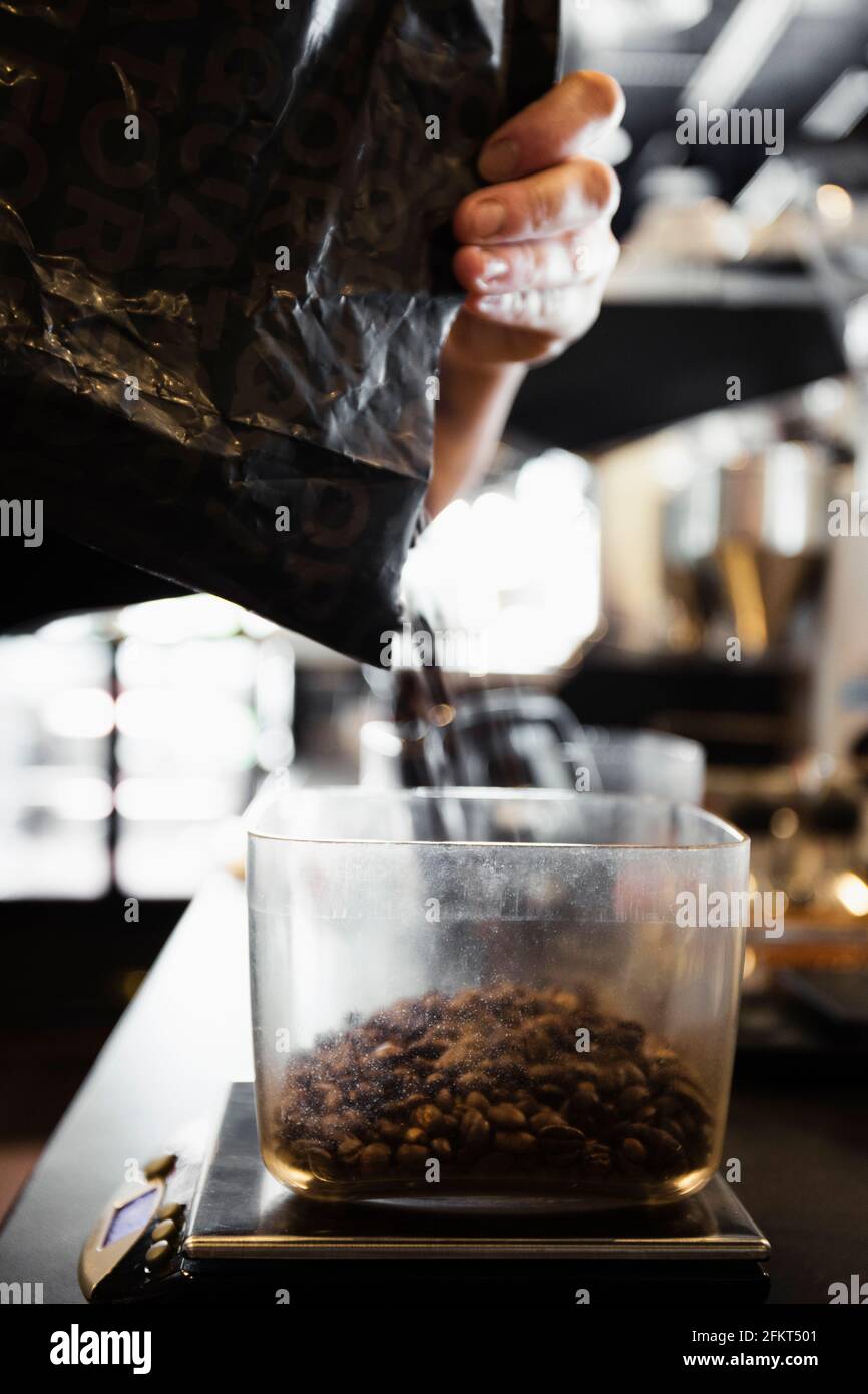 Coffee shop barista pouring coffee beans, close-up Stock Photo - Alamy