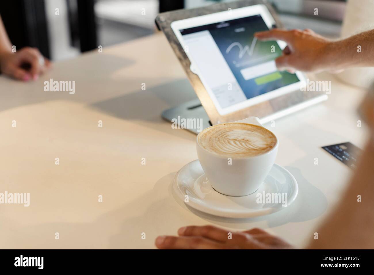 Customer paying for coffee in coffee shop, signing signature on digital ...