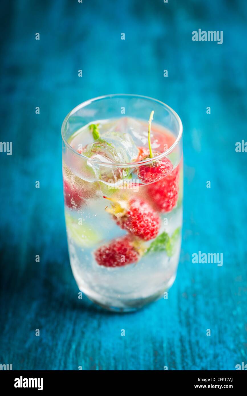 Sweet summer cocktail with raspberry and lime on the rustic background ...