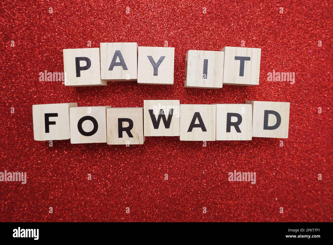 Pay it forward alphabet letters top view on red glitter background ...