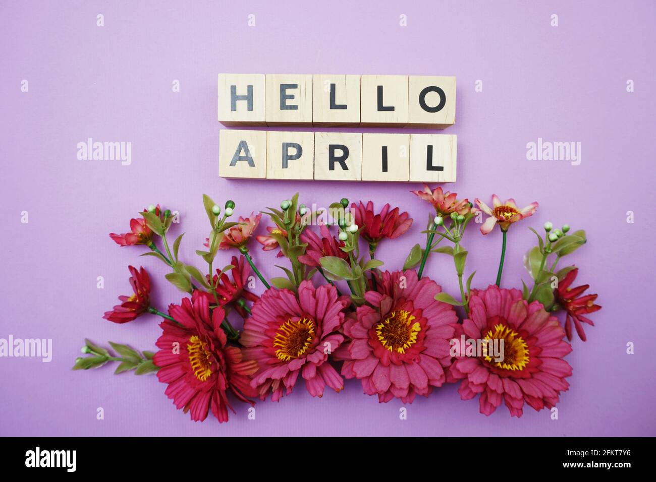 Hello April alphabet letters with flower decoration top view on purple ...