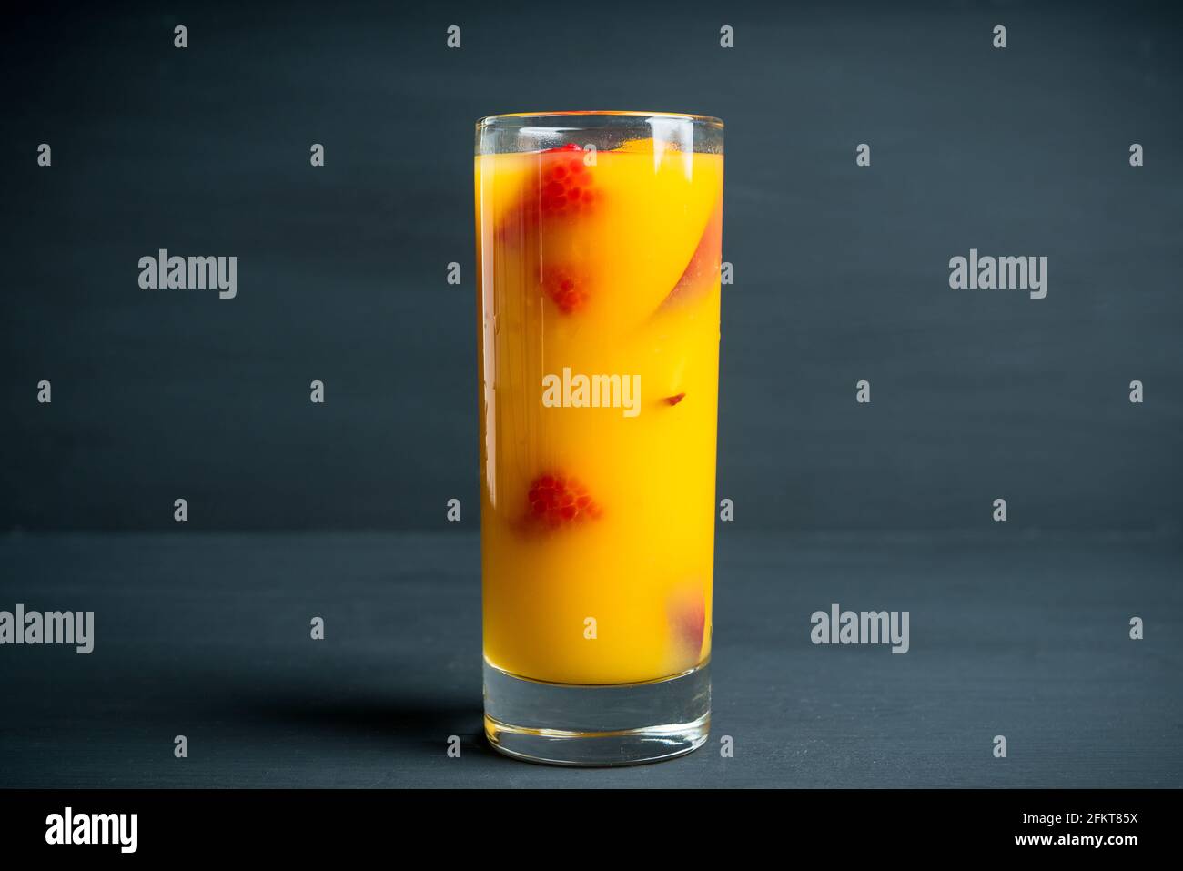 Fresh peach beverage with red ripe raspberry on the rustic background ...