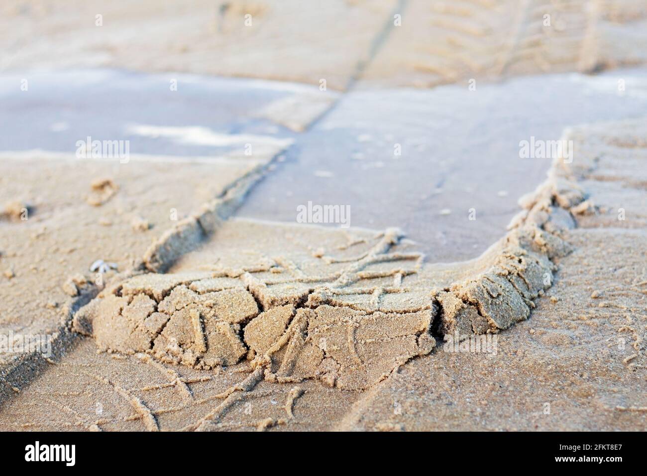 Wheel marks on sand at the sea with background Stock Photo - Alamy
