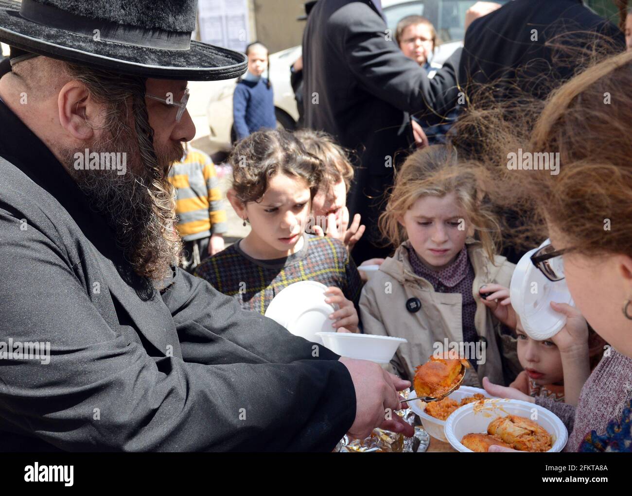 Jewish Orthodox children waiting in line for food and sweets served by ...