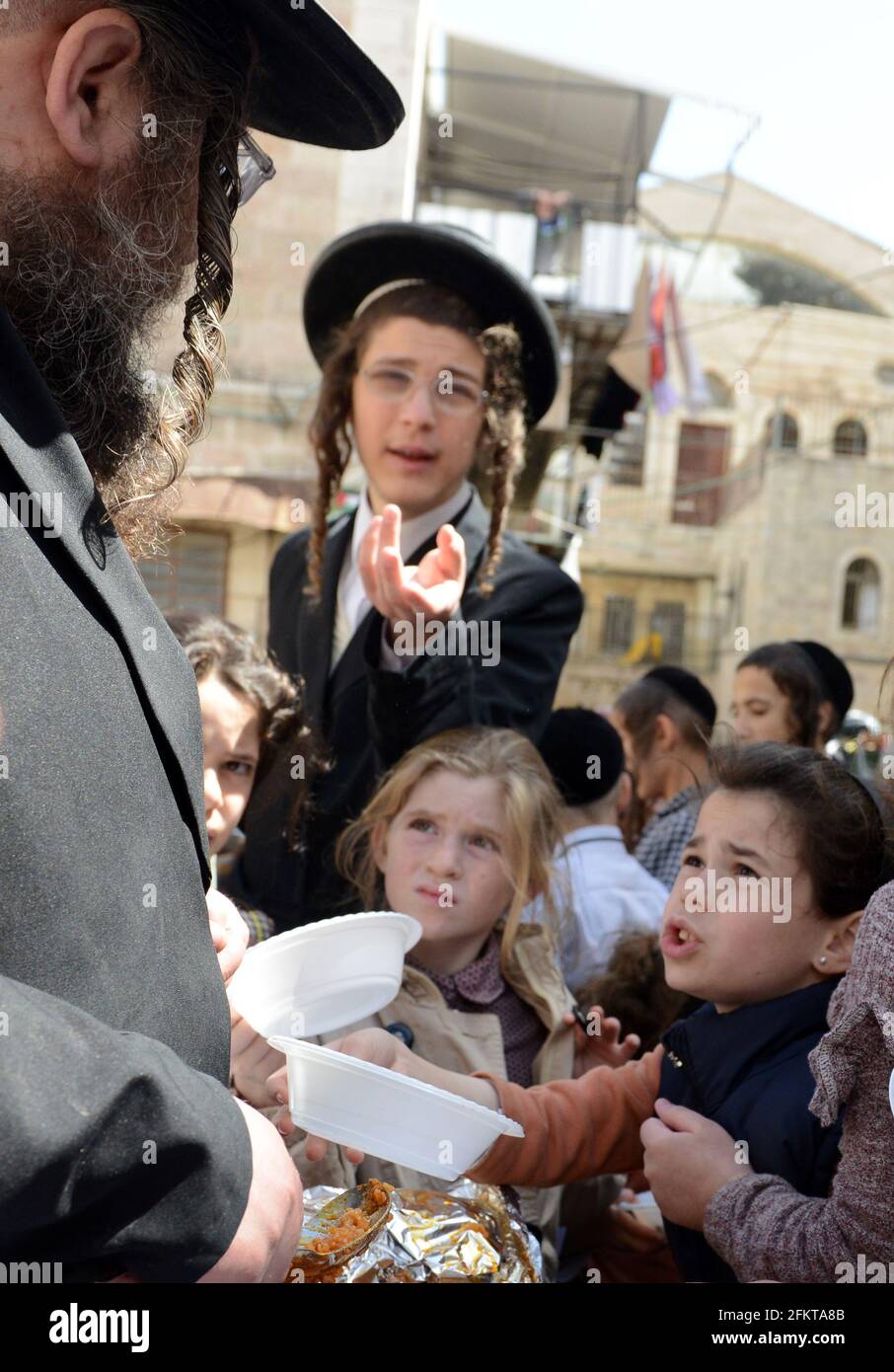 Jewish Orthodox children waiting in line for food and sweets served by ...