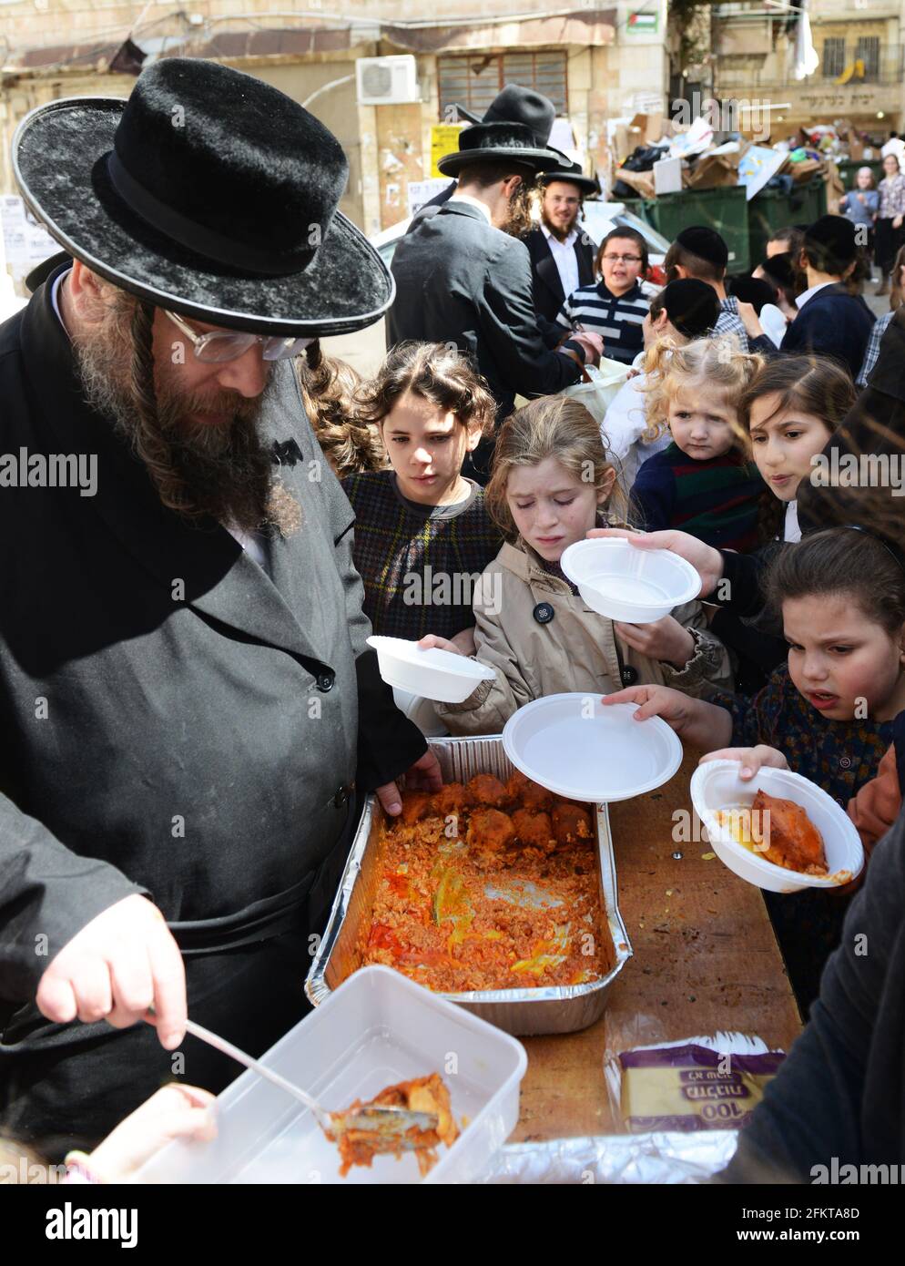 Jewish Orthodox children waiting in line for food and sweets served by ...