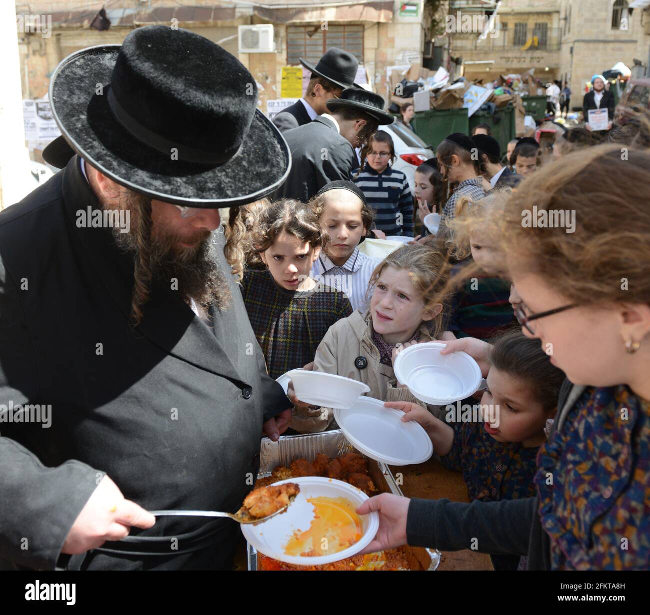 Jewish Orthodox children waiting in line for food and sweets served by ...