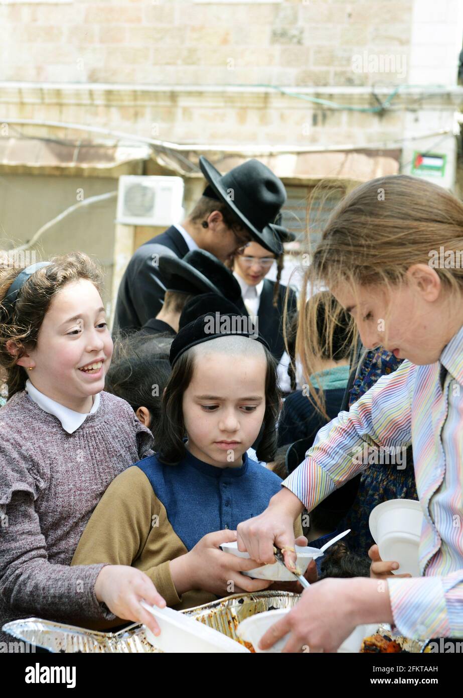 Jewish Orthodox children waiting in line for food and sweets served by ...