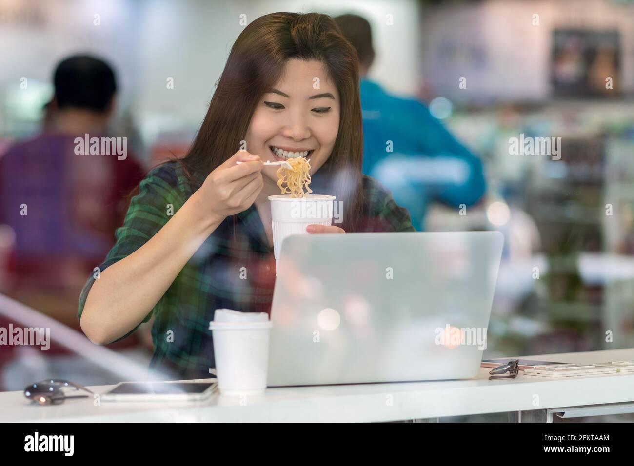 Portrait of asian businesswoman in casual suit eating noodles with ...