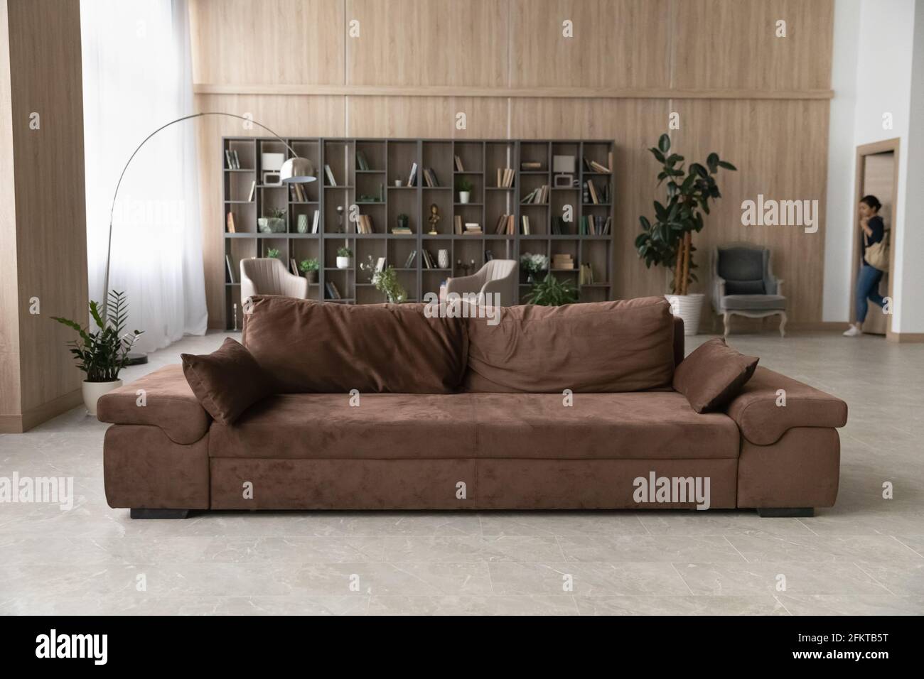 Indian woman returning home, entering into empty modern living room ...