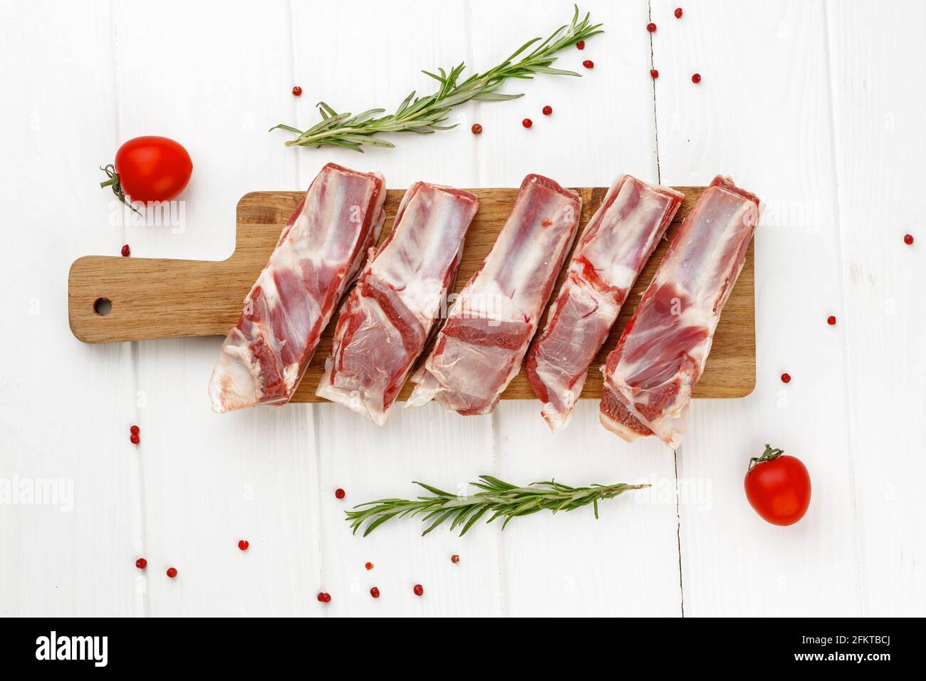 Raw meat ribs on wooden board on white background Stock Photo - Alamy