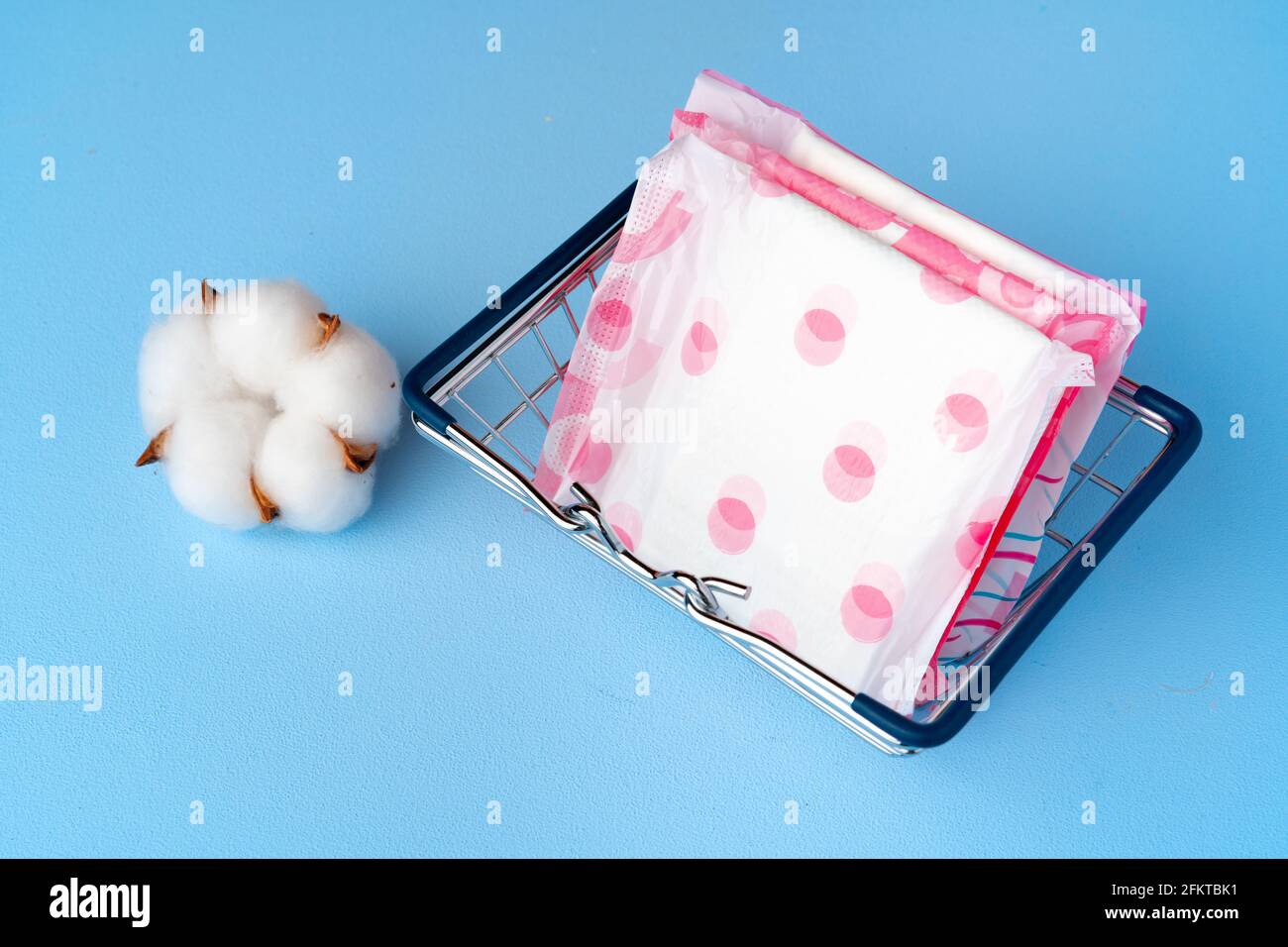 Female pads in shopping cart on paper background Stock Photo - Alamy