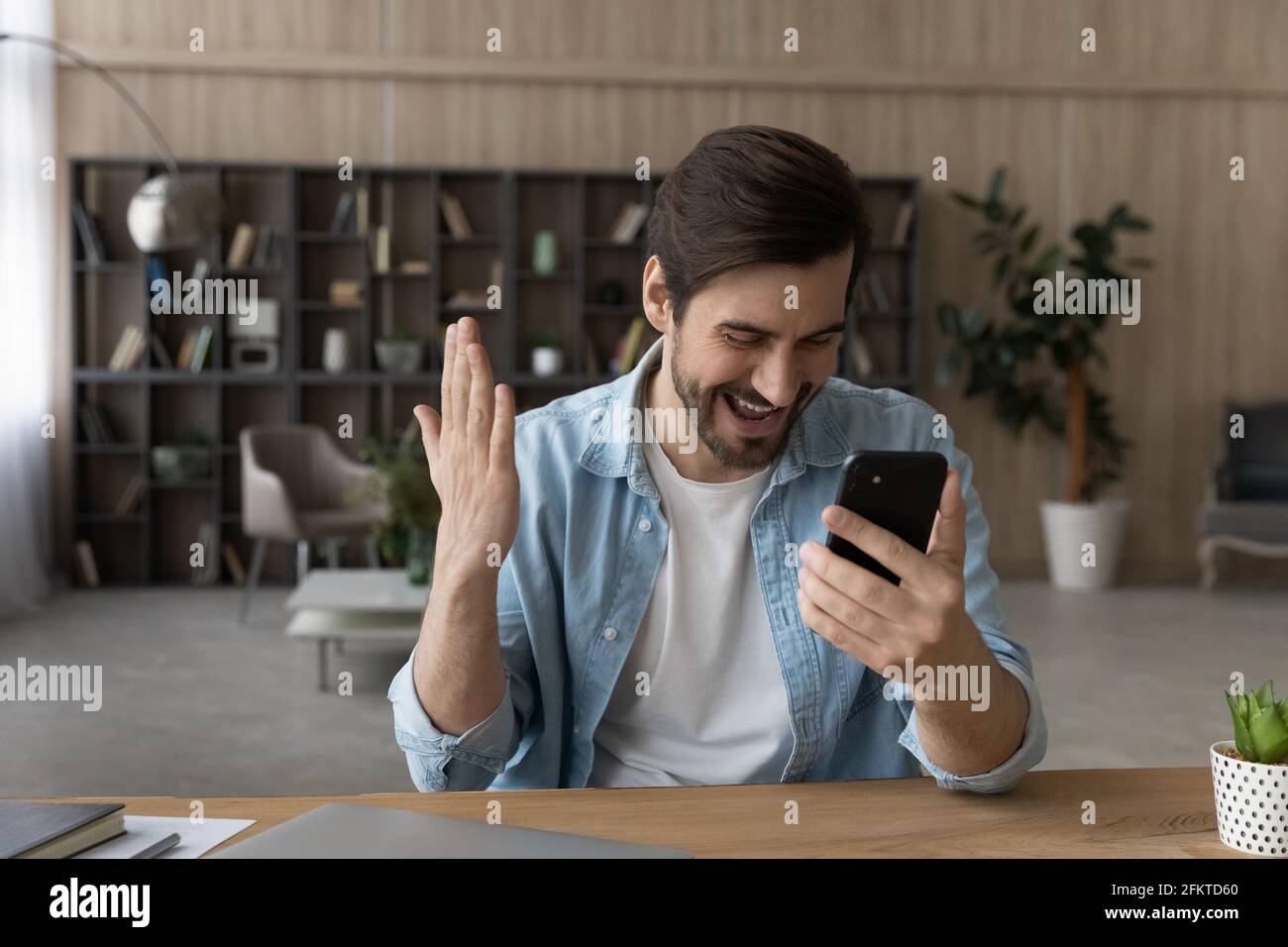 Overjoyed surprised man reading good news in message, using smartphone ...