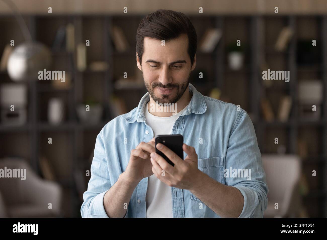 Close up satisfied man using phone, looking at screen Stock Photo - Alamy