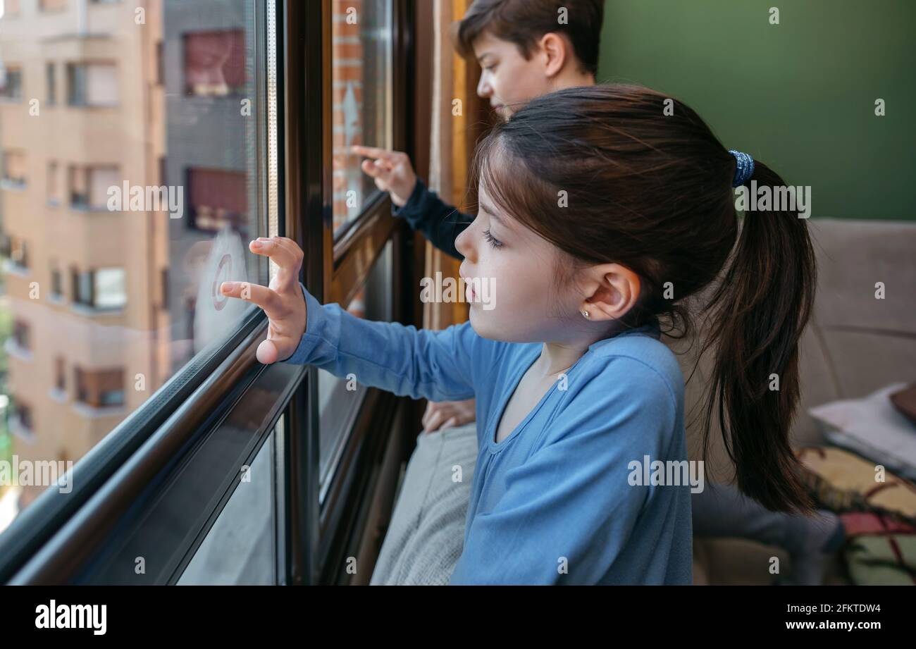 Two children in coronavirus lockdown drawing on the window Stock Photo ...