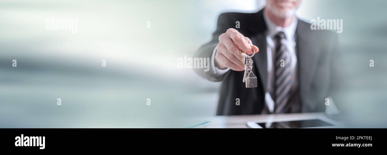 Real estate agent offering house keys; panoramic banner Stock Photo - Alamy