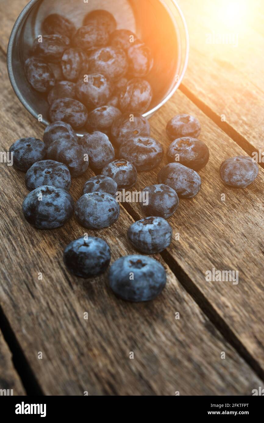 Blueberry berries spilled from metal bucket onto wooden table Stock ...