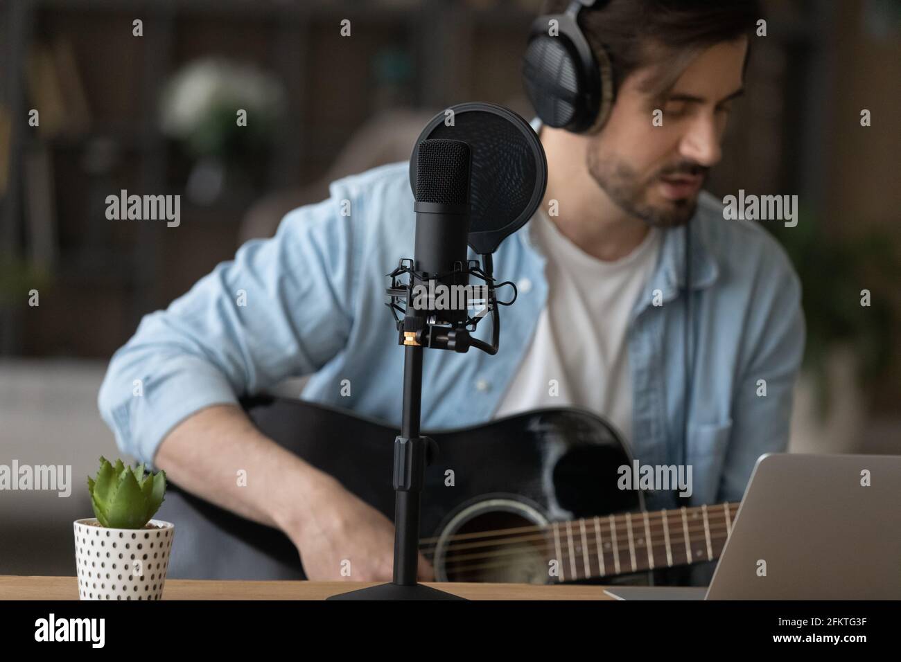 Close up professional microphone, man playing guitar, recording song ...