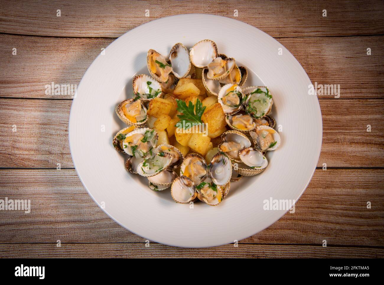 Steamed cockles with fried potatoes in the white dish, mariniere recipe ...