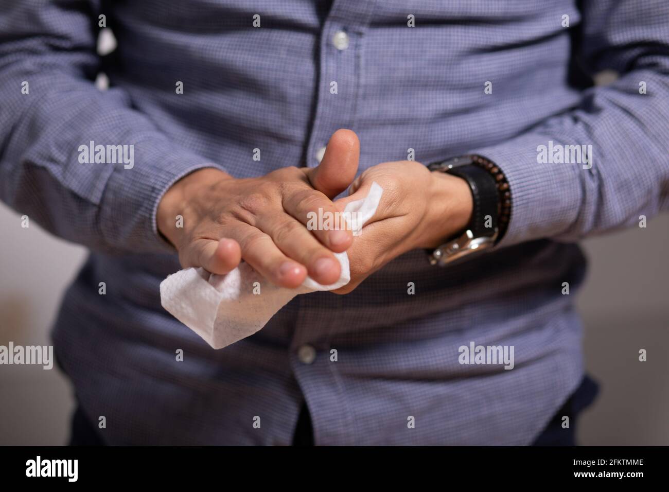 Young man cleaning hands with wet wipes Stock Photo - Alamy