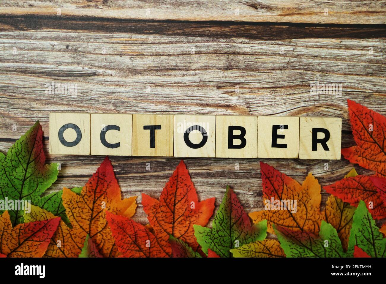 October alphabet letter with maple leaves frame on wooden background ...