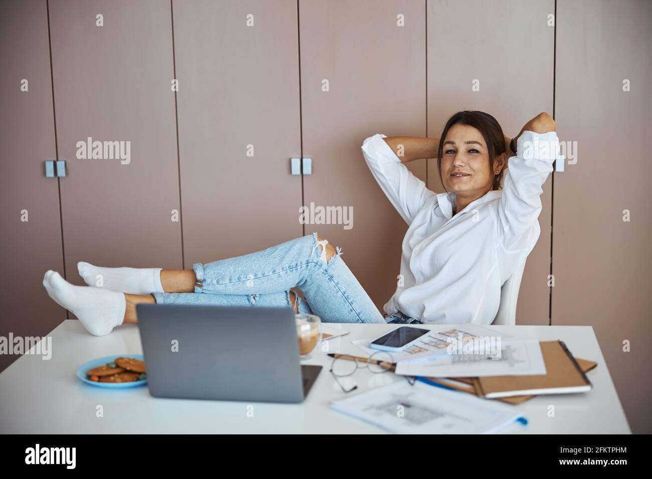 Beautiful woman sitting at the table with laptop at work Stock Photo ...