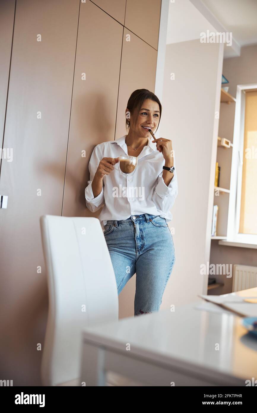 Beautiful cheerful woman drinking coffee at work Stock Photo - Alamy