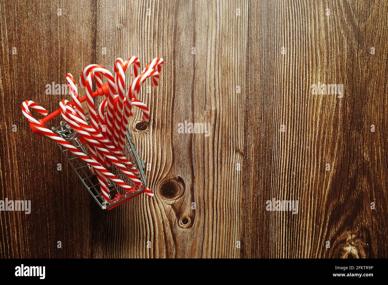 Christmas Candy Cane in mini shopping cart on wooden background Stock ...