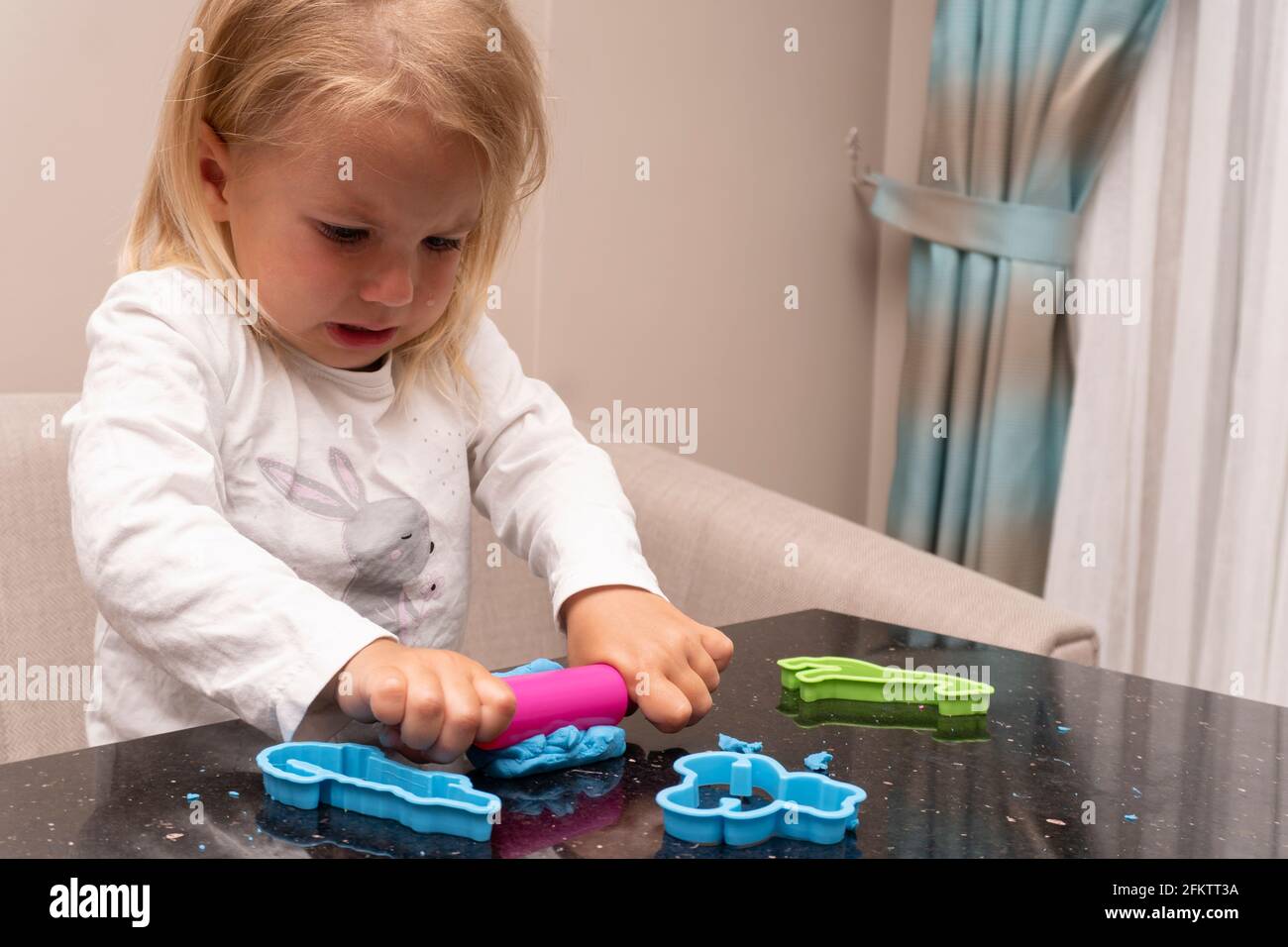 Crying kid plays with colorful playdough Stock Photo - Alamy