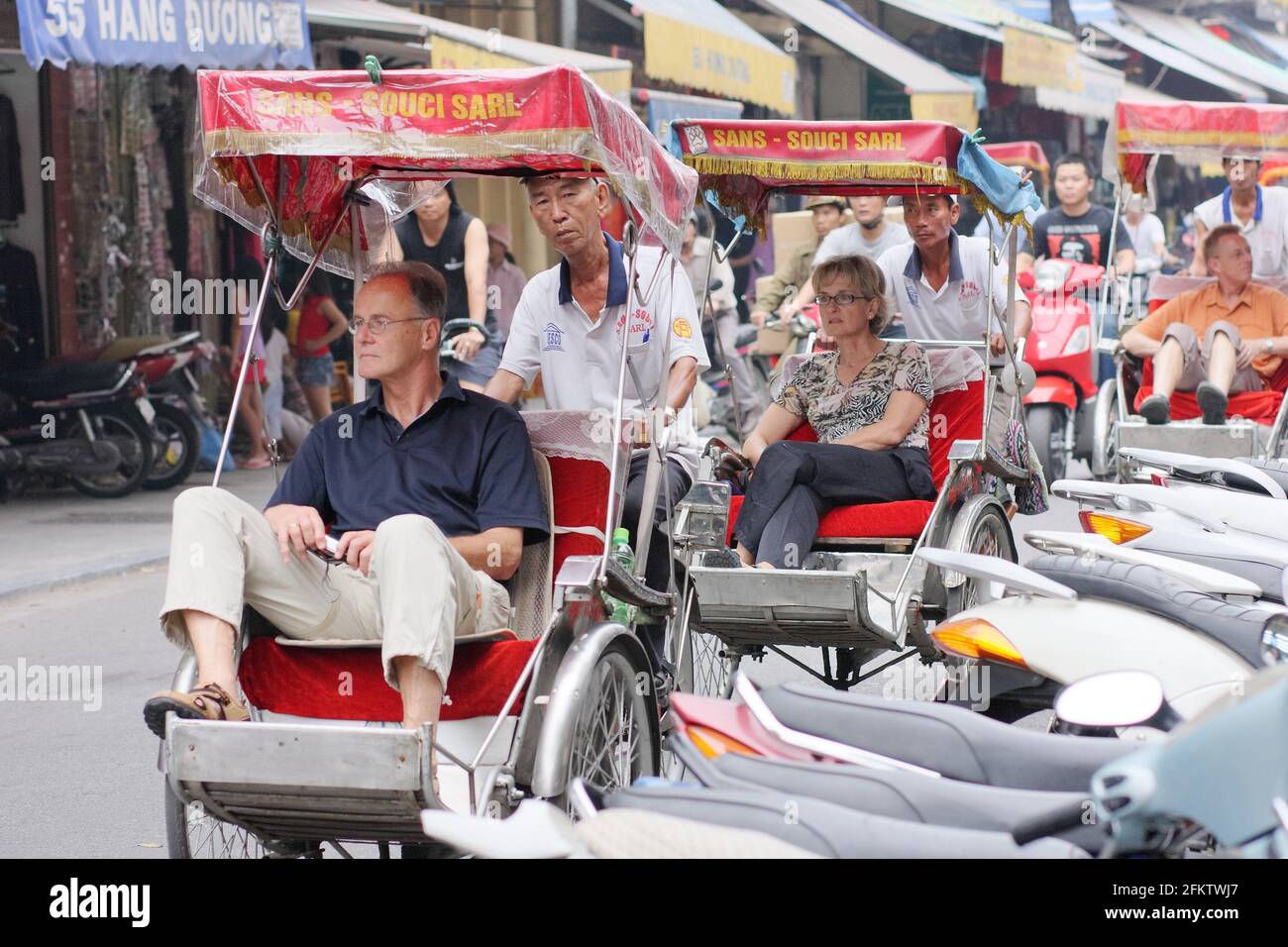 A tourist in a cyclo rickshaw on a busy street in the Old Quarter ...