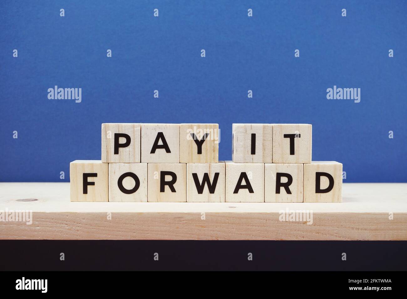 Pay It Forward alphabet letter on blue and wooden shelves background ...