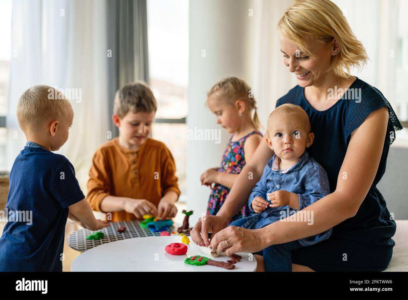 Family activities in the kids room. Woman and children playing together ...