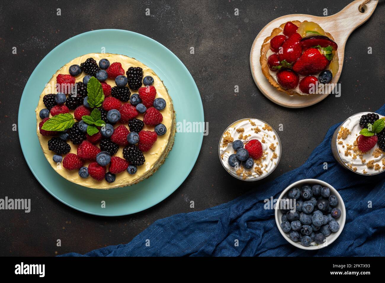 Homemade cake with fresh berries and sweet desserts on dark background ...