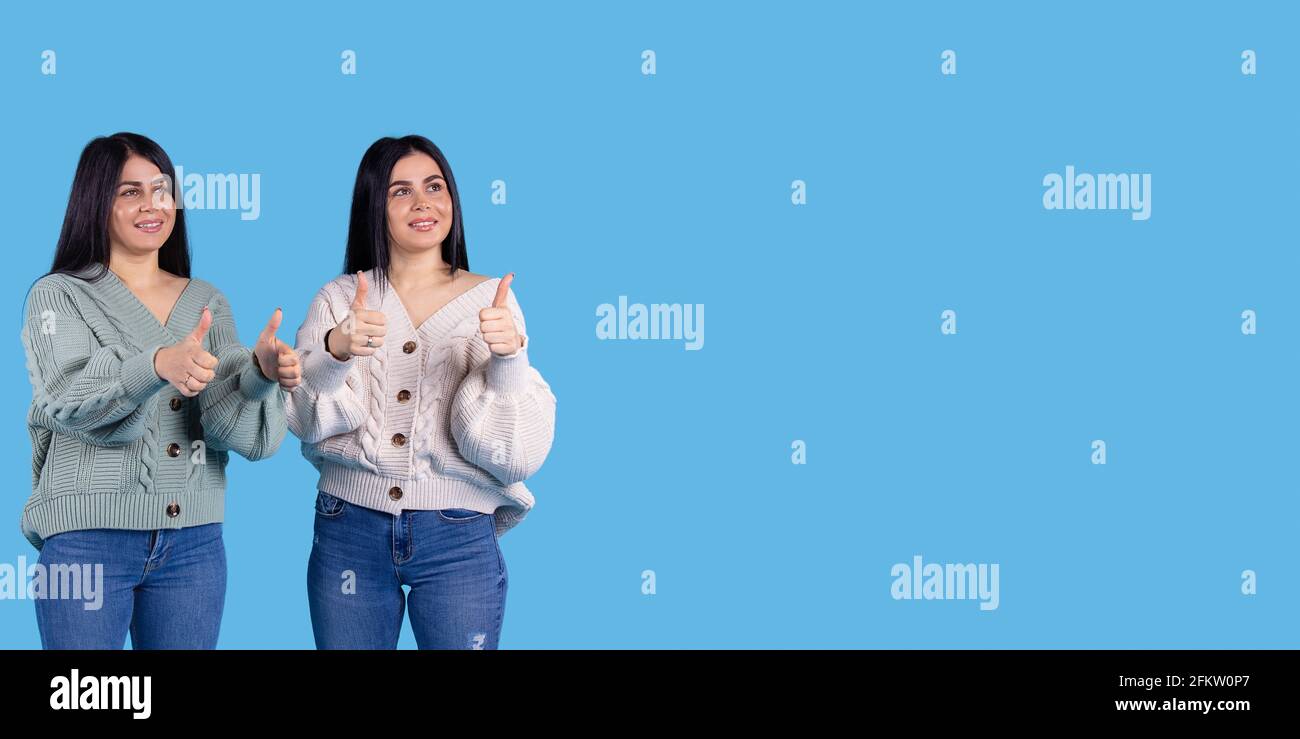 Banner,long format. The twin women look to the side and point their ...