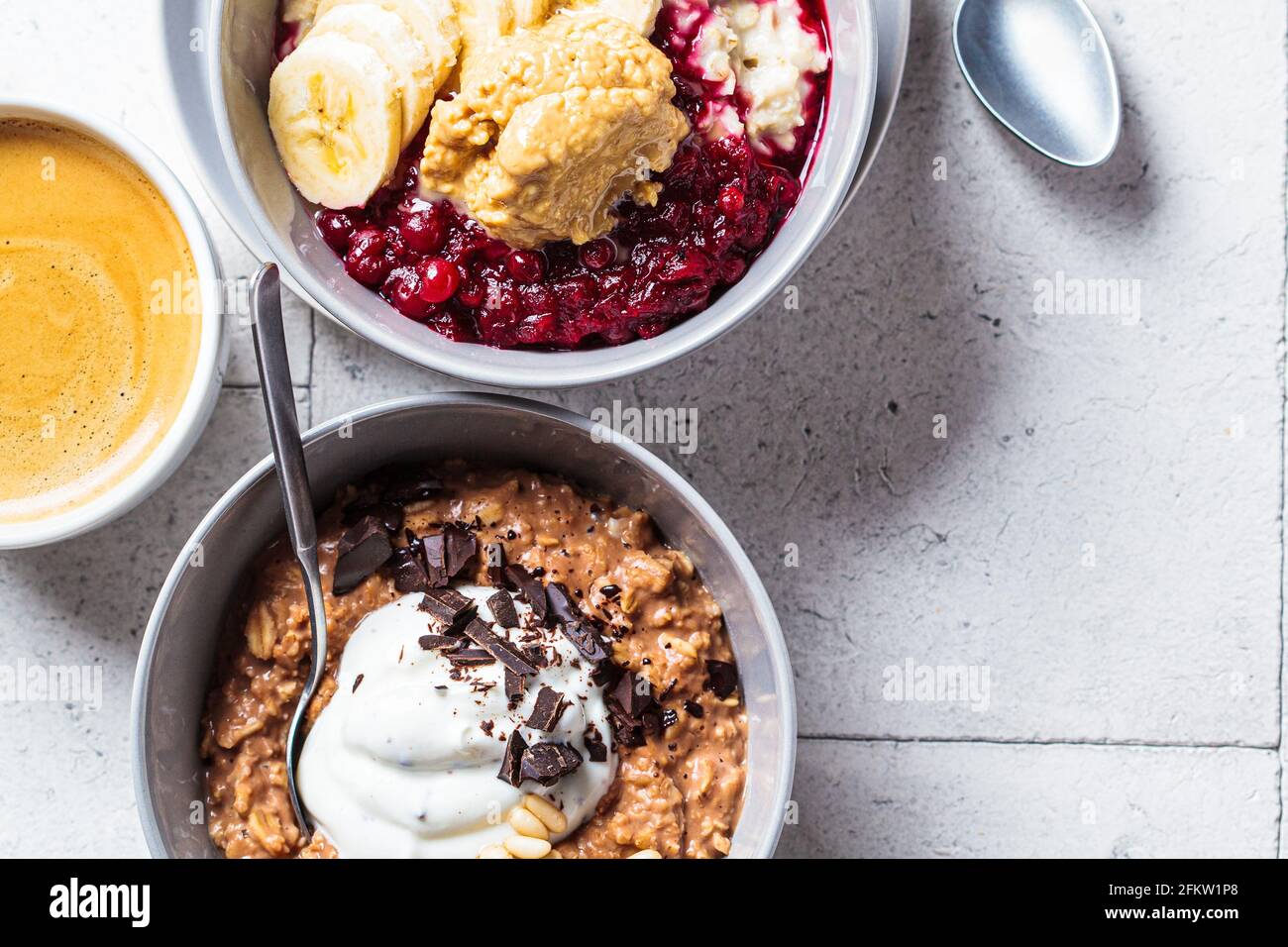 Assorted oatmeal bowls with chocolate, fruit and yogurt, gray tiles ...