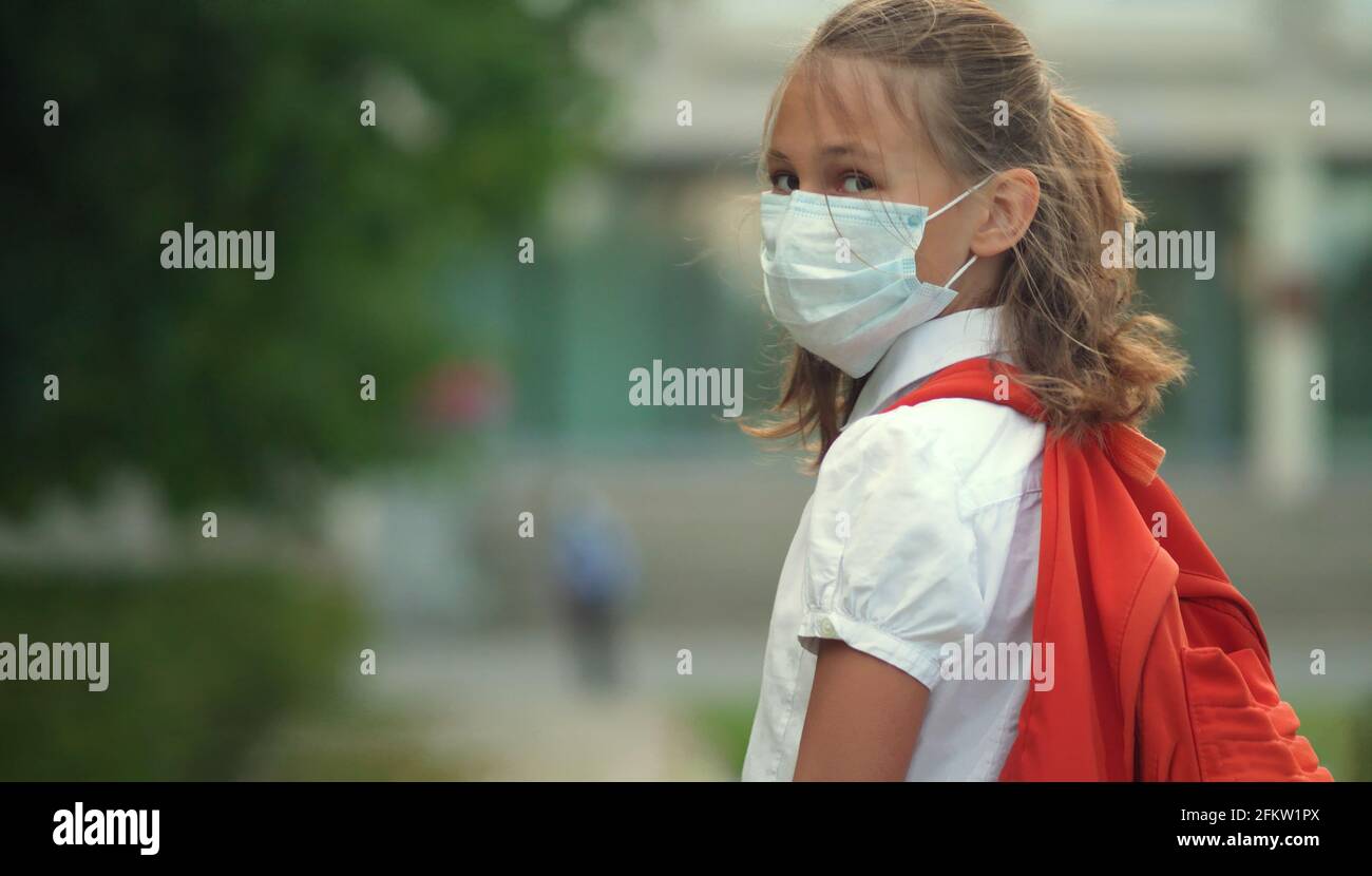 Child goes back to school. Cute pupil with backpack. Girl in safety ...