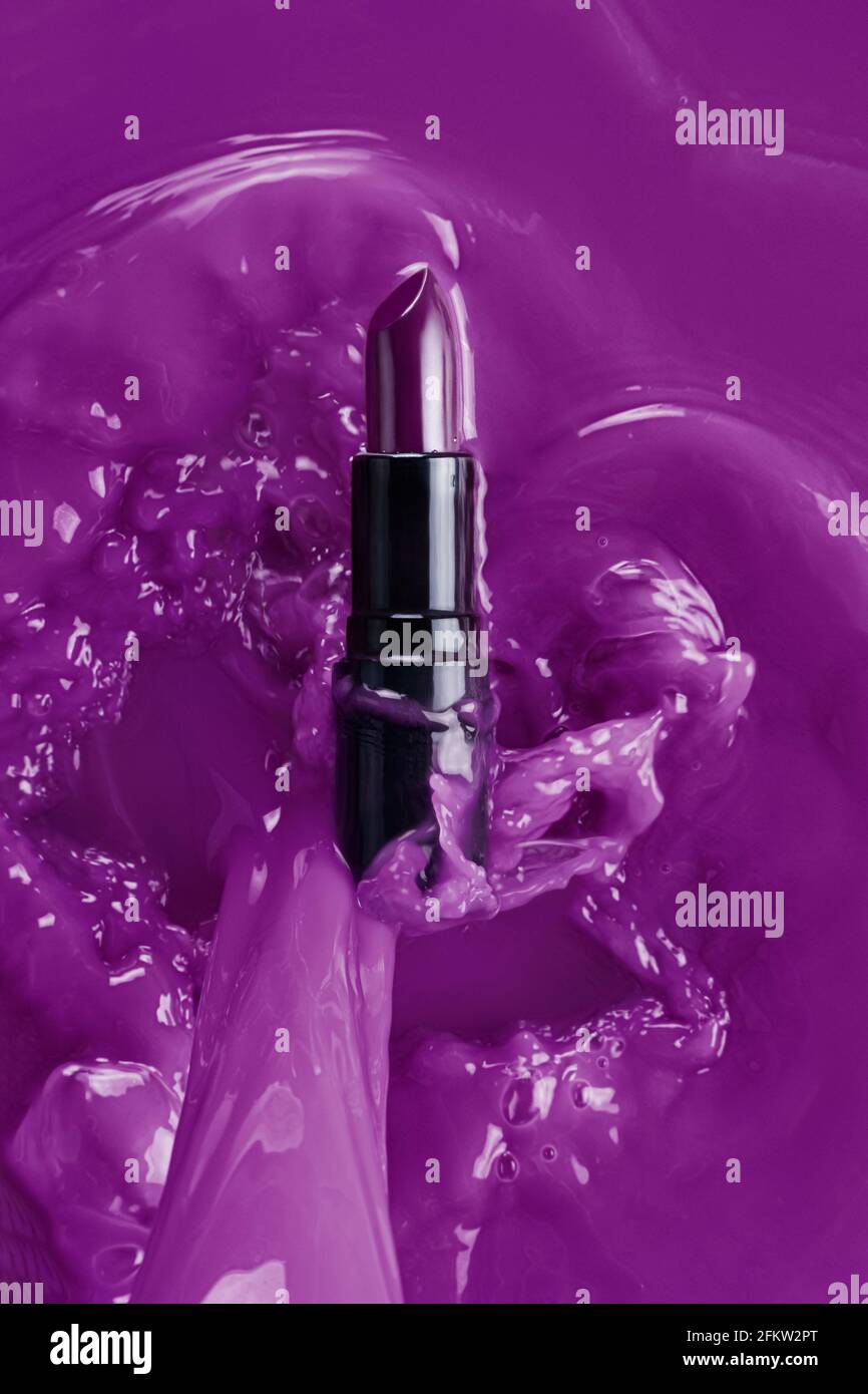 Purple lipstick in violet liquid flow. Top view Stock Photo - Alamy