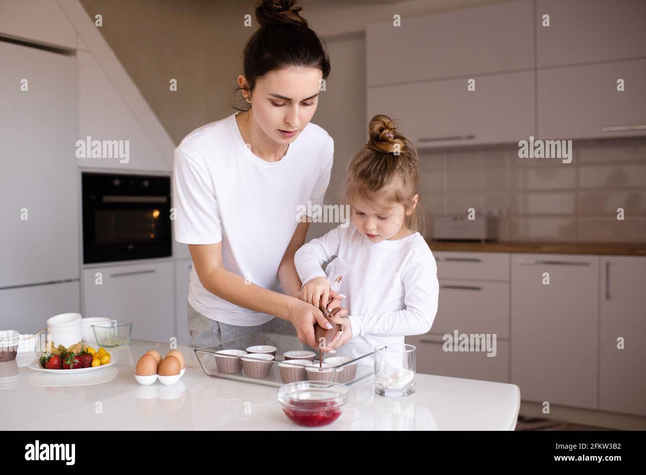 young-mother-cook-cupcakes-with-little-child-daughter-2-3-year-old-at