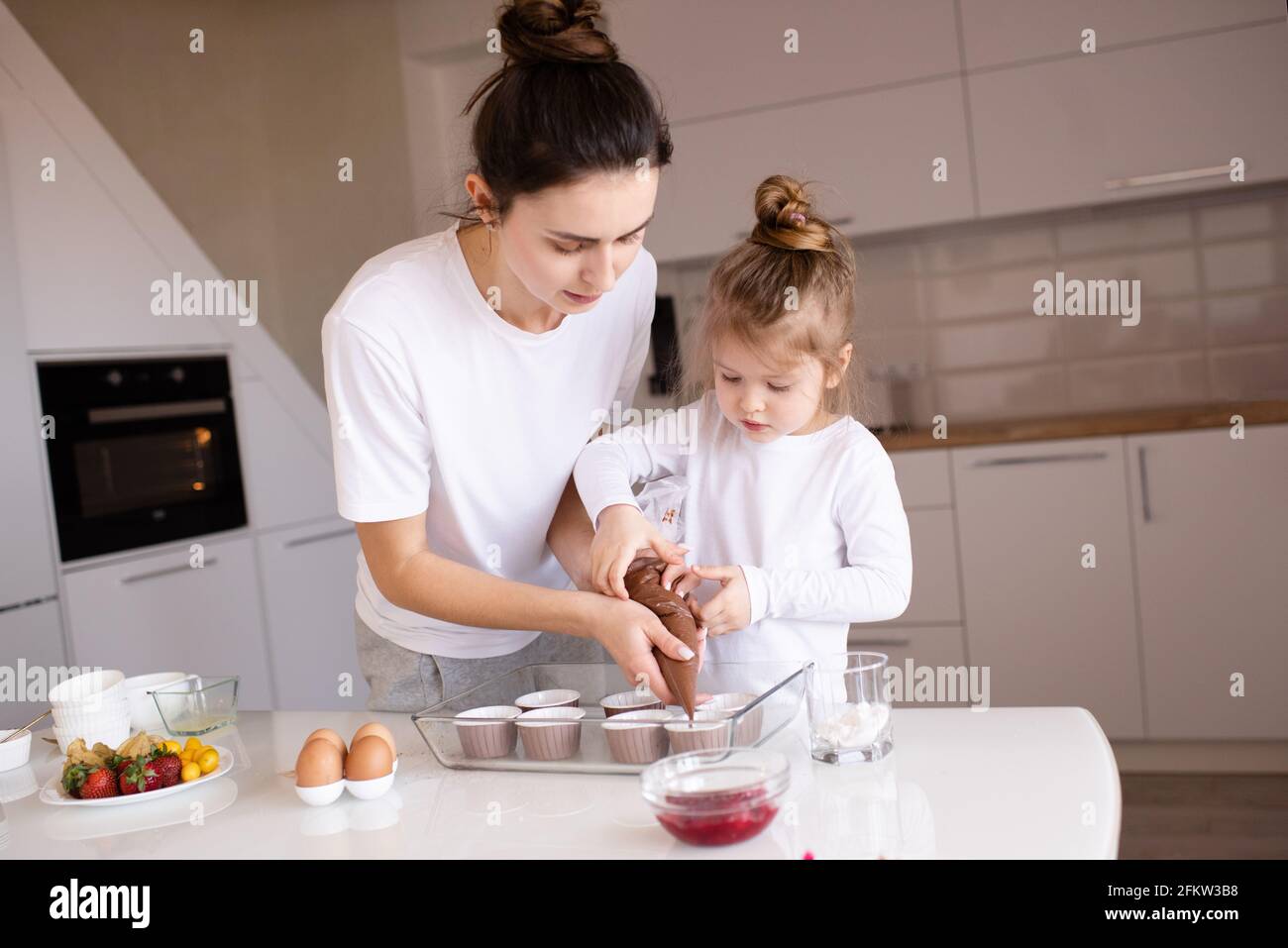 young-mother-cook-cupcakes-with-little-child-daughter-2-3-year-old-at