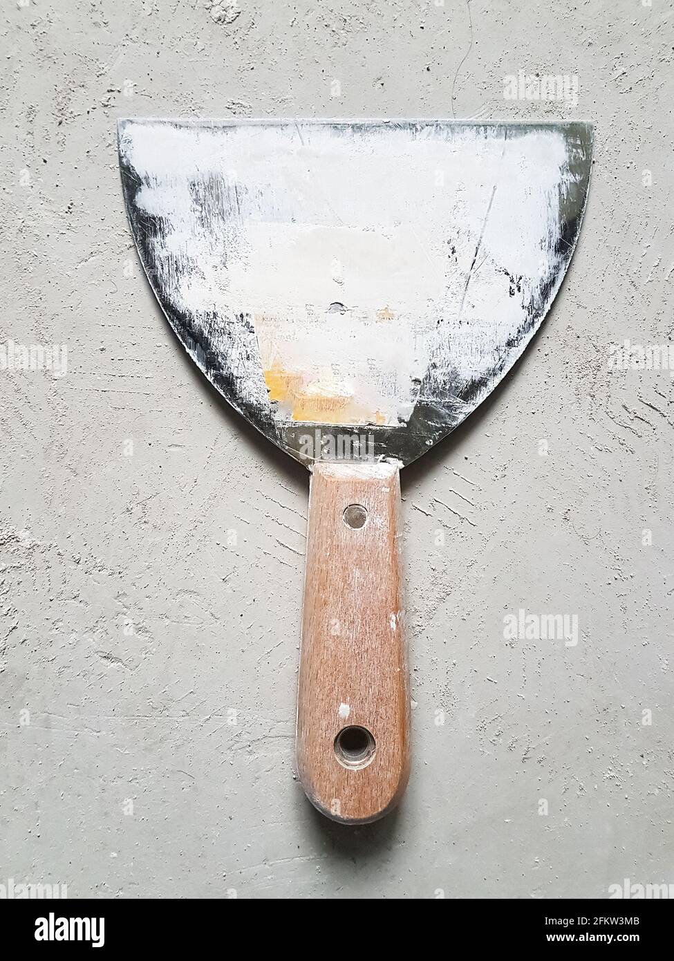 Putty knife stained with putty - laying on cement floor Stock Photo - Alamy