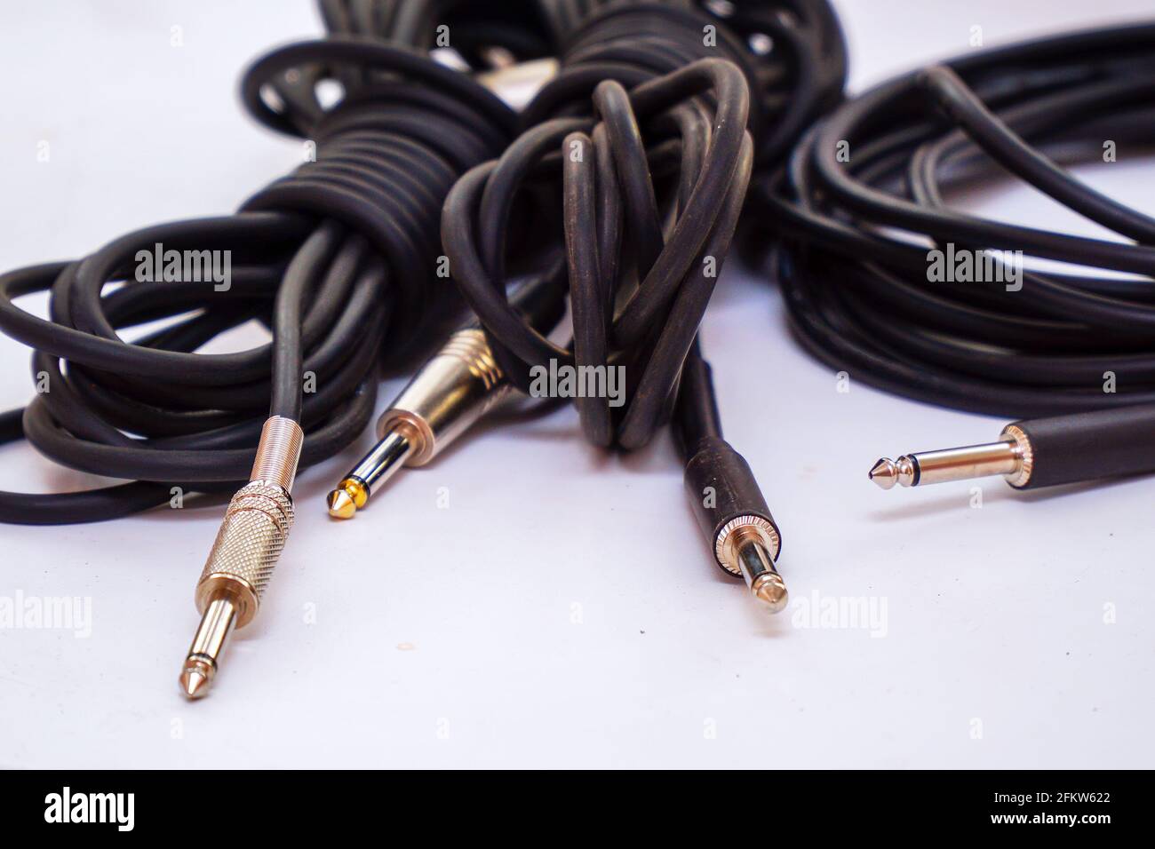 Audio cables for musical instruments and microphones on a white ...