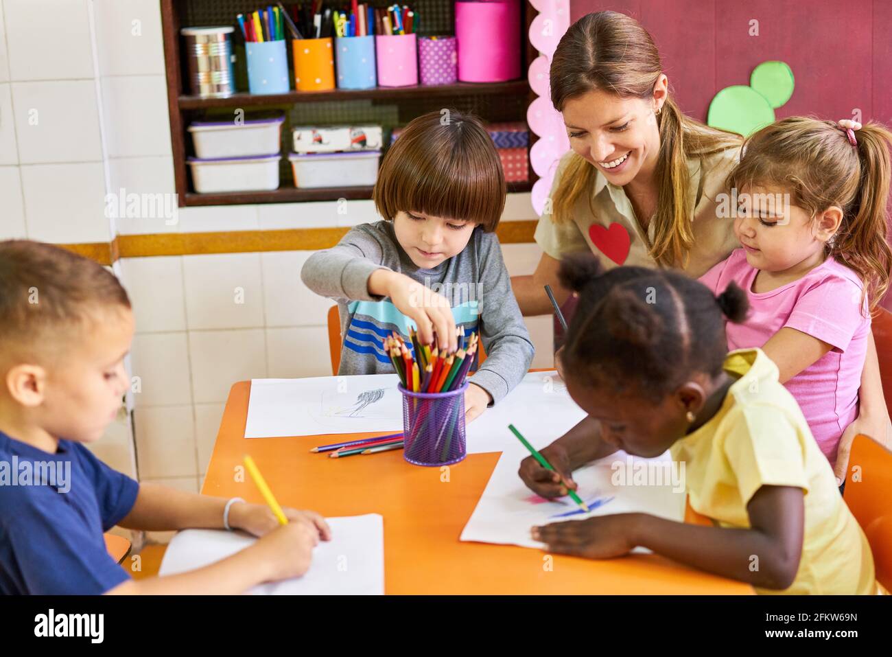 Group of children and educators painting and drawing in the painting ...