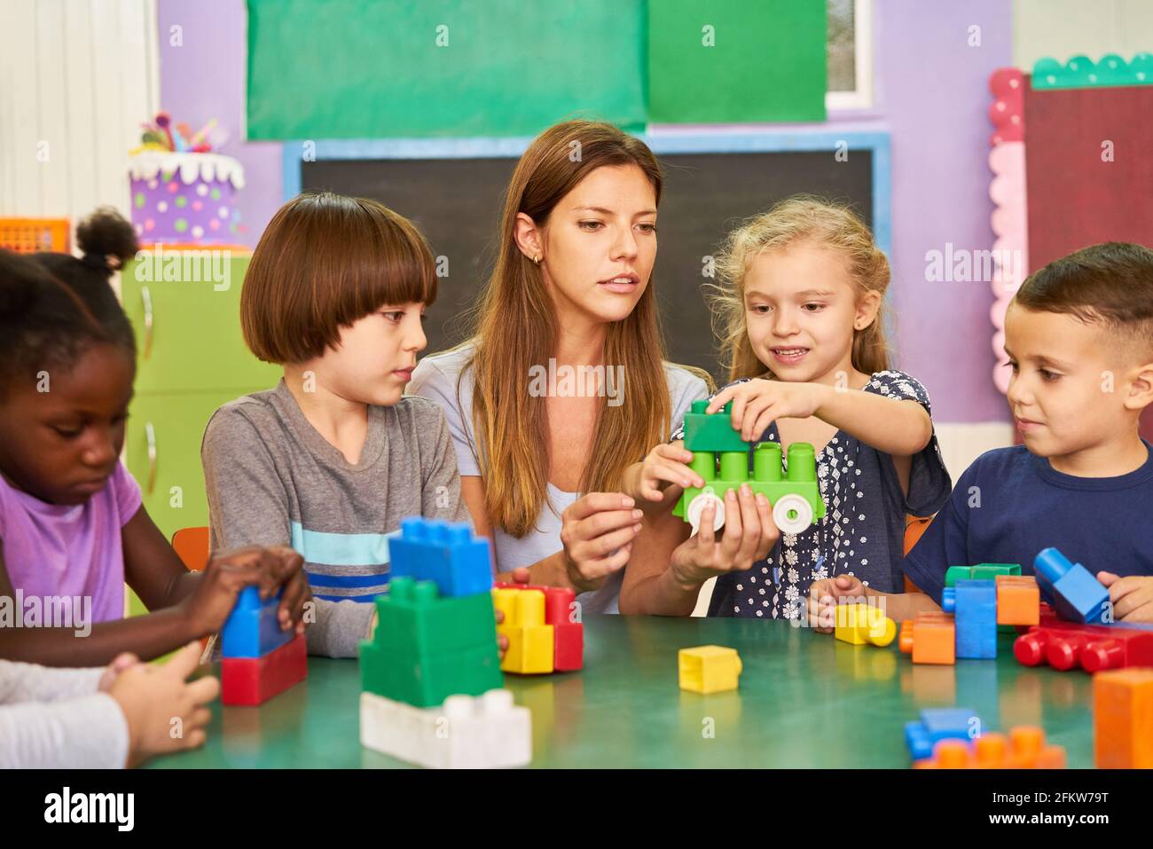 Group of children in kindergarten playing with building blocks together ...