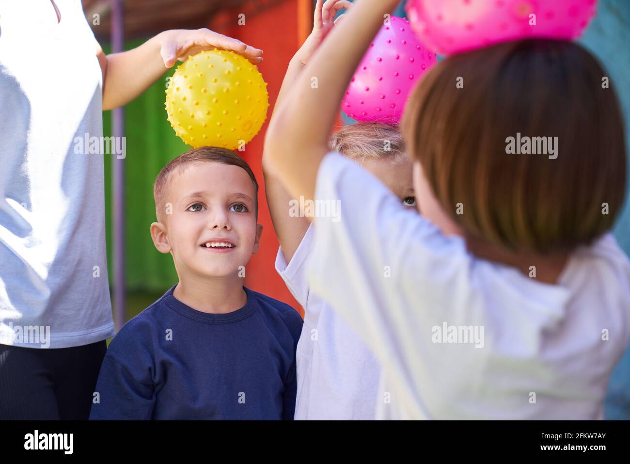 Children have fun playing ball outside in front of kindergarten in ...